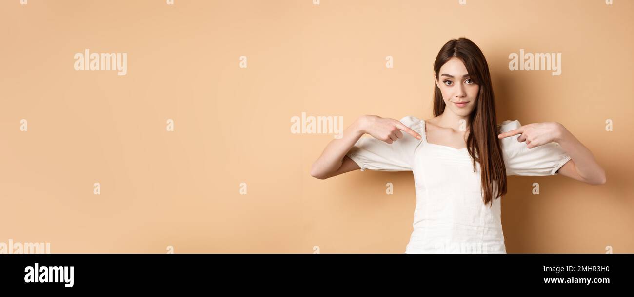 Young serious woman pointing at center, showing logo with confident ...