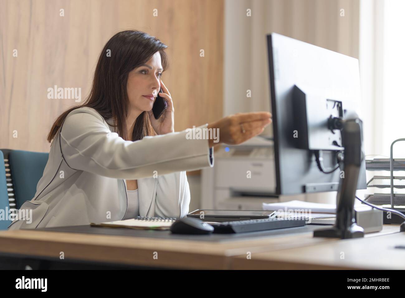 Executive female manager in a suit works at a computer in the office ...