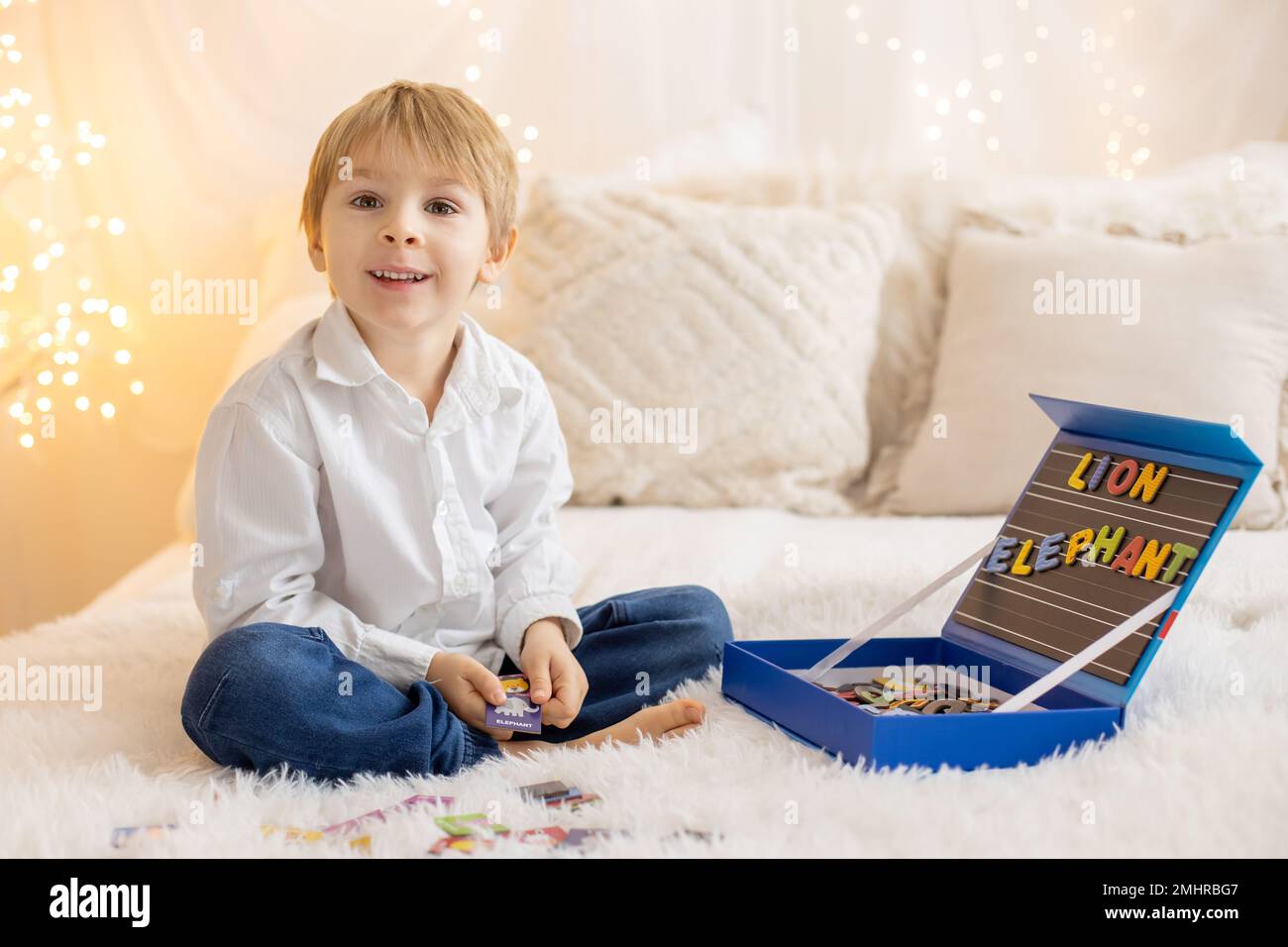 Cute little preschool child, playing with alphabet game, learning ...