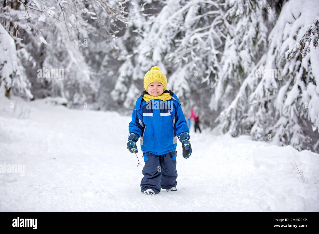Sweet happy child, playing in deep snow in forest Stock Photo - Alamy