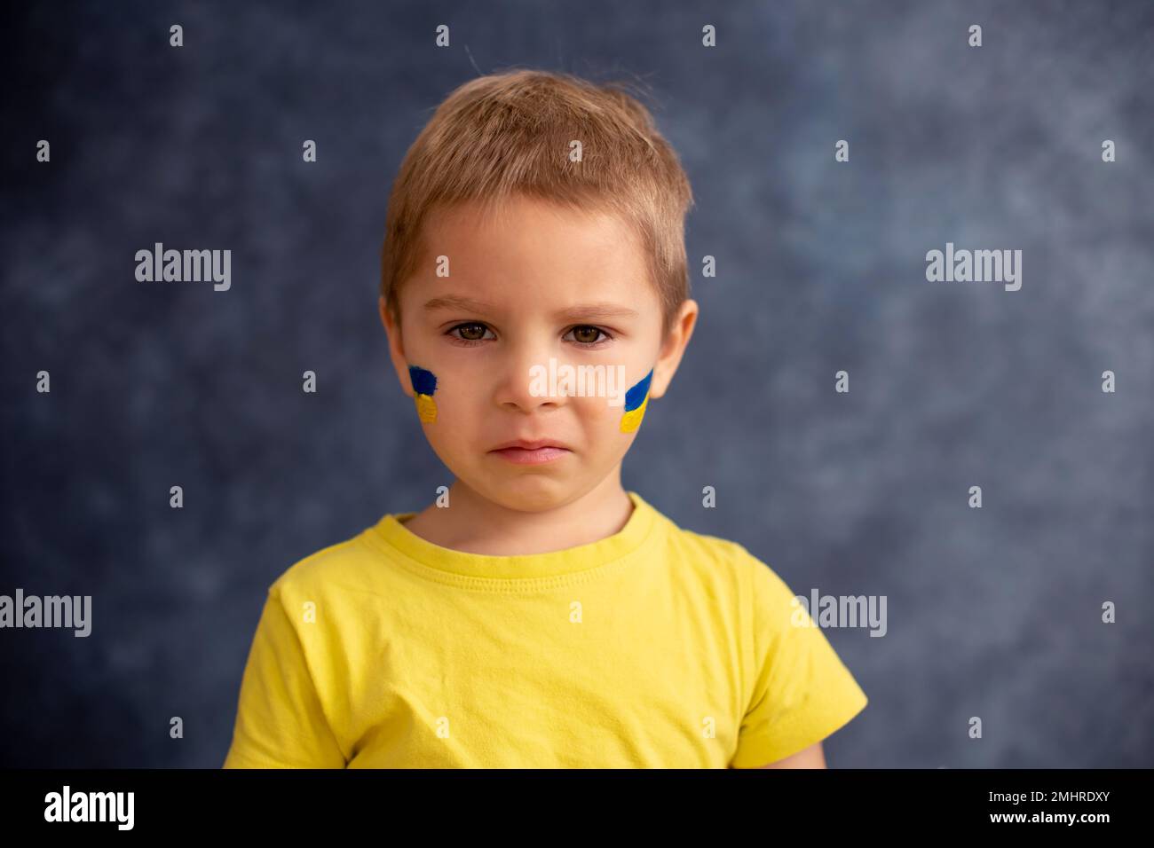 Young blond child, holding sign in support to peace, no war wanted, kid ...