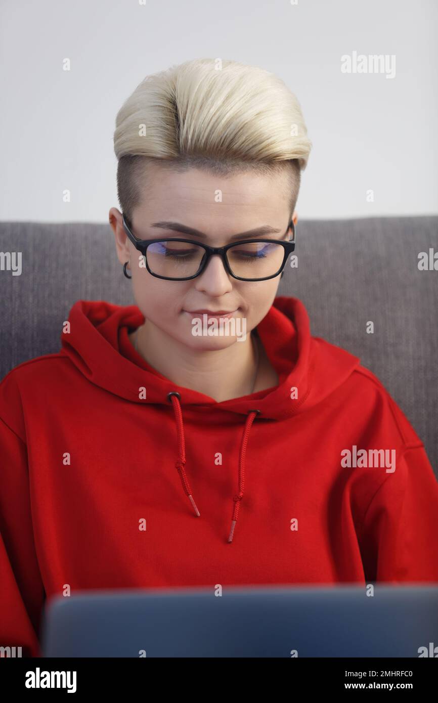 Portrait of short haired woman in nerd glasses coding on laptop. Female ...