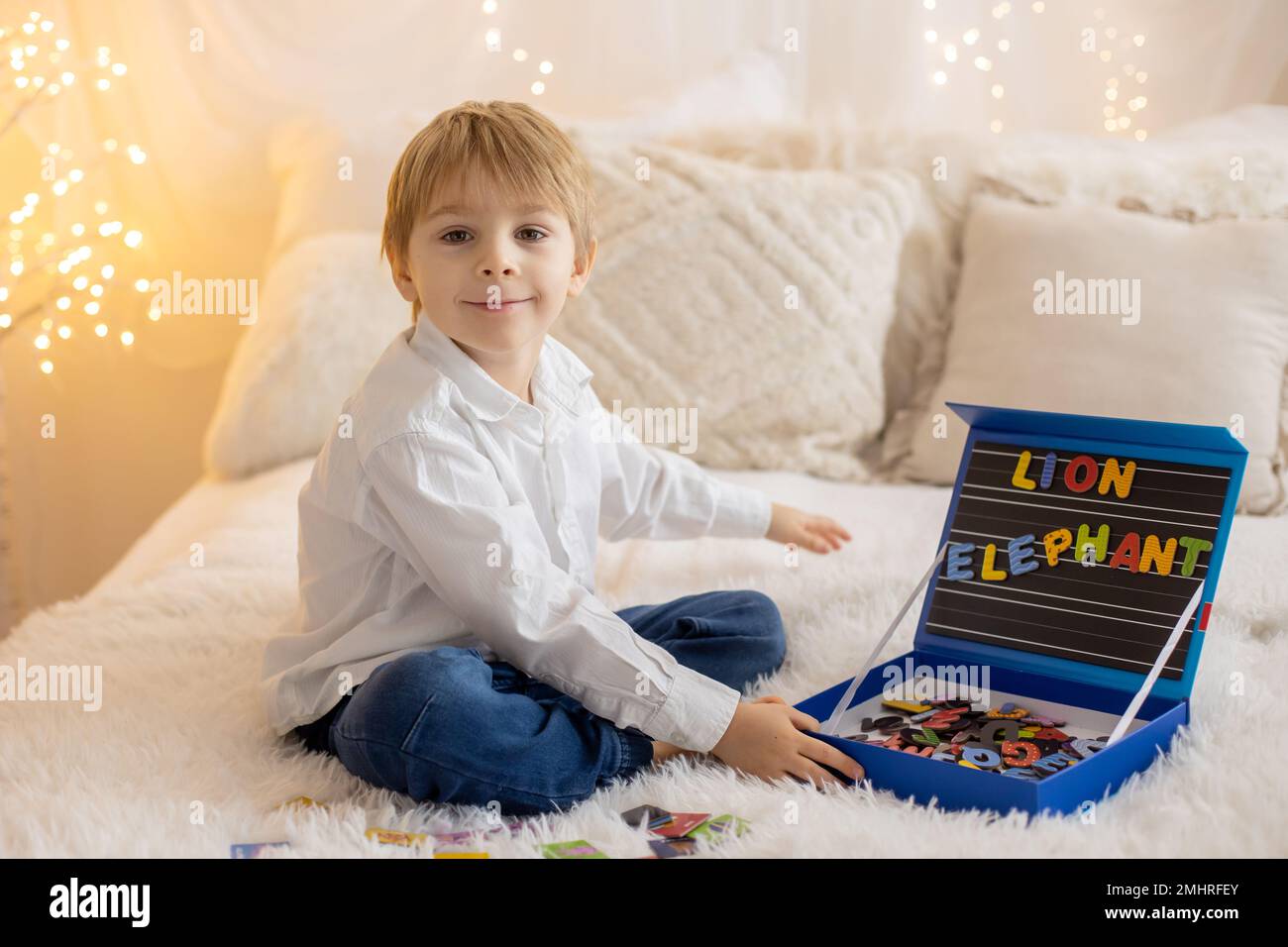 Cute little preschool child, playing with alphabet game, learning ...