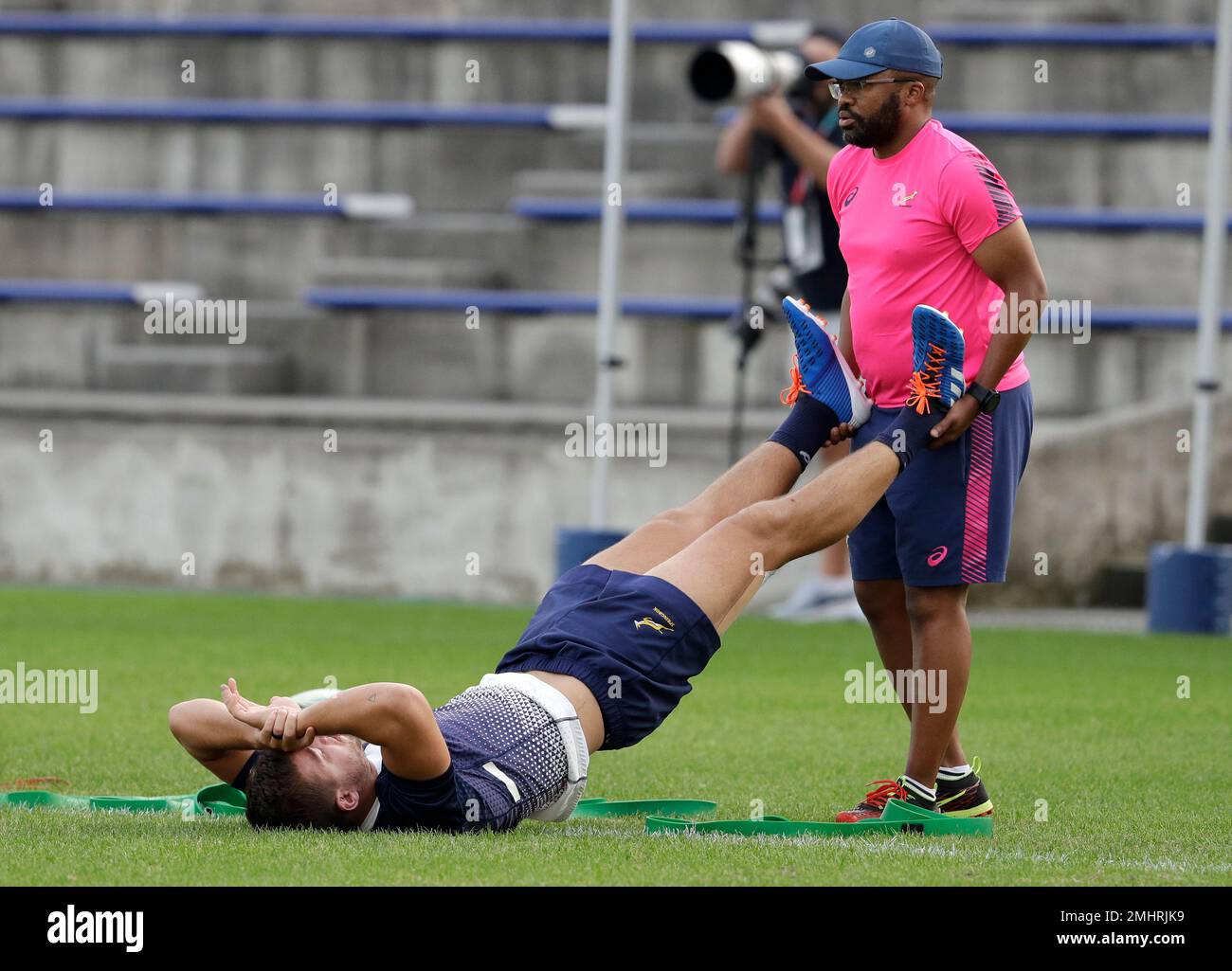 South Africa's Handre Pollard stretches with trainer during a training ...