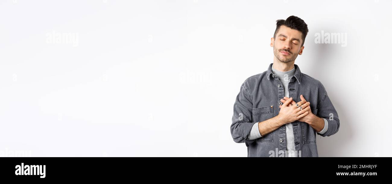 Nostalgic man hold hands on heart, remember tender memories, standing ...