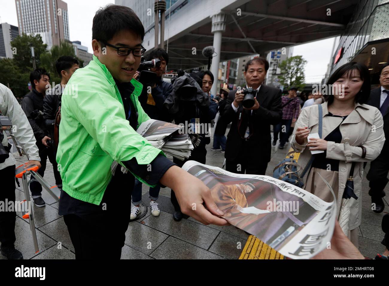 A Yomiuri Newspaper Worker Hands A Copy Of The Extra Edition Reporting