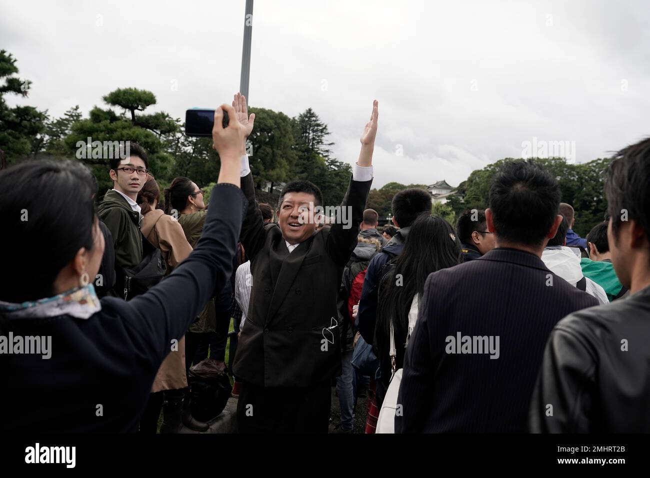 A man celebrates with "banzai" cheers as people gather outside of the ...