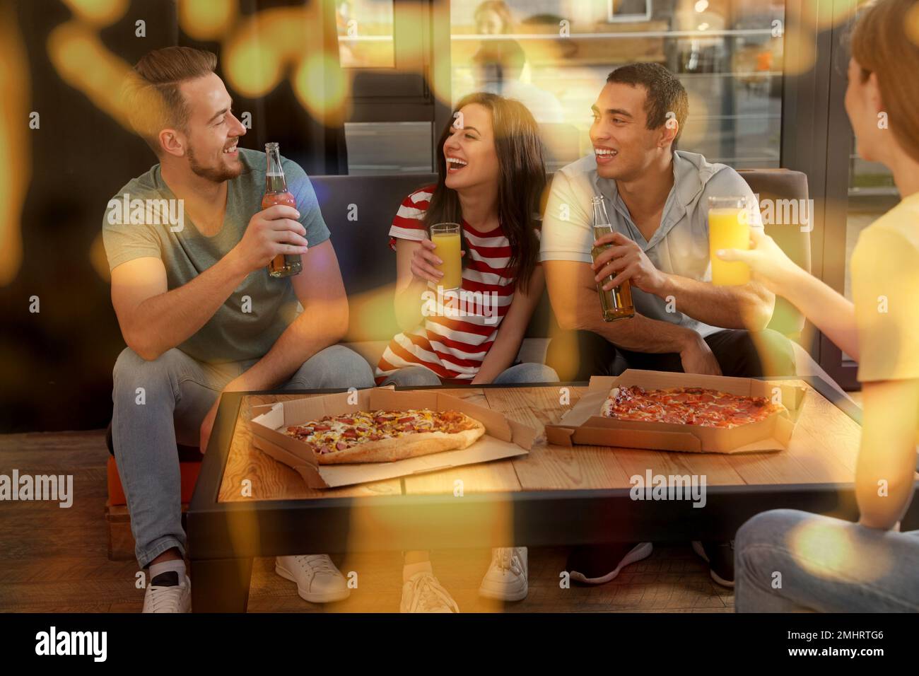 Group of friends having fun party with delicious pizza in cafe, bokeh ...