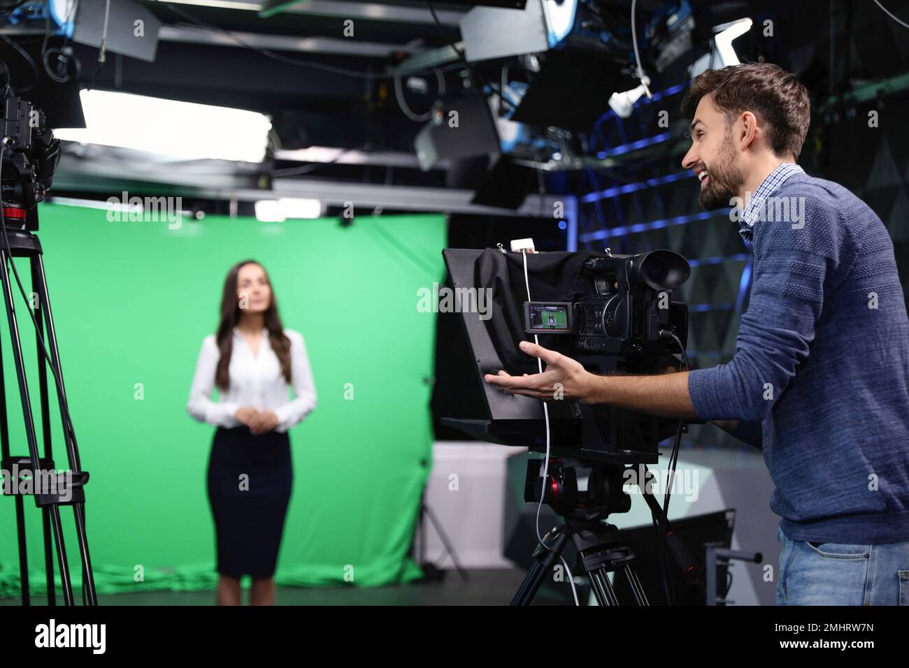 Presenter and video camera operator working in studio. News ...