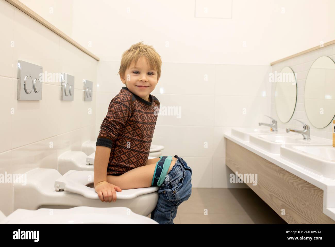 Cute child, blond boy., going to toilet in kindergarden Stock Photo - Alamy