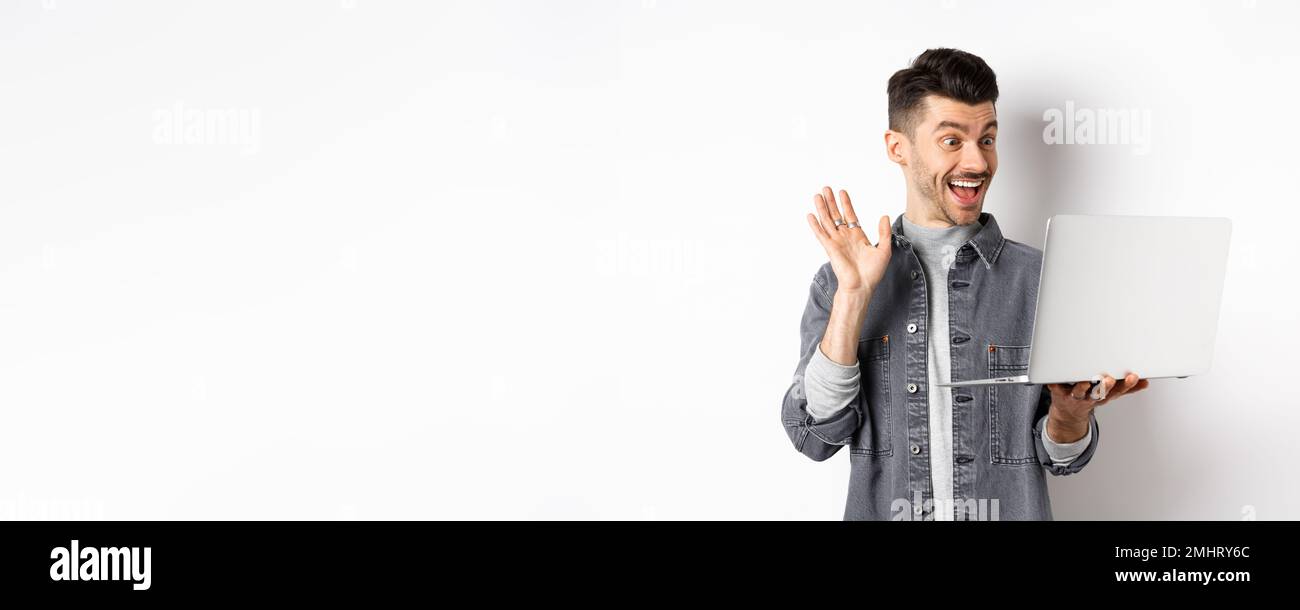 Excited man waiving hand at laptop, video chatting on computer and ...