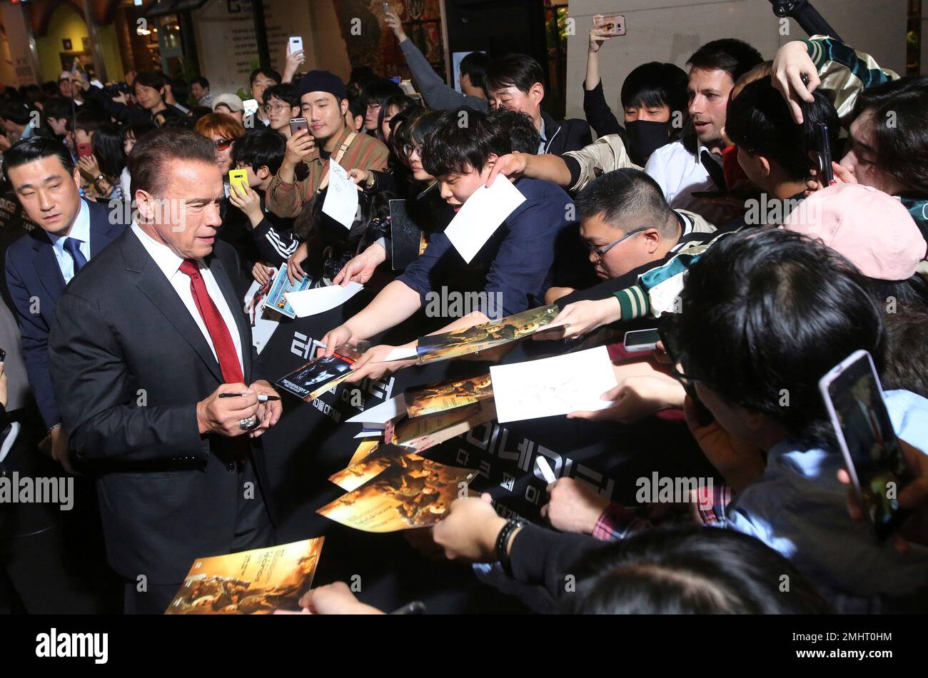 Actor Arnold Schwarzenegger is greeted by fans during the premiere of ...
