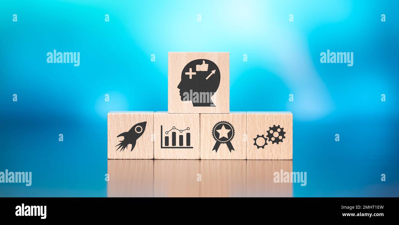 Wooden blocks with symbol of motivation concept on blue background ...
