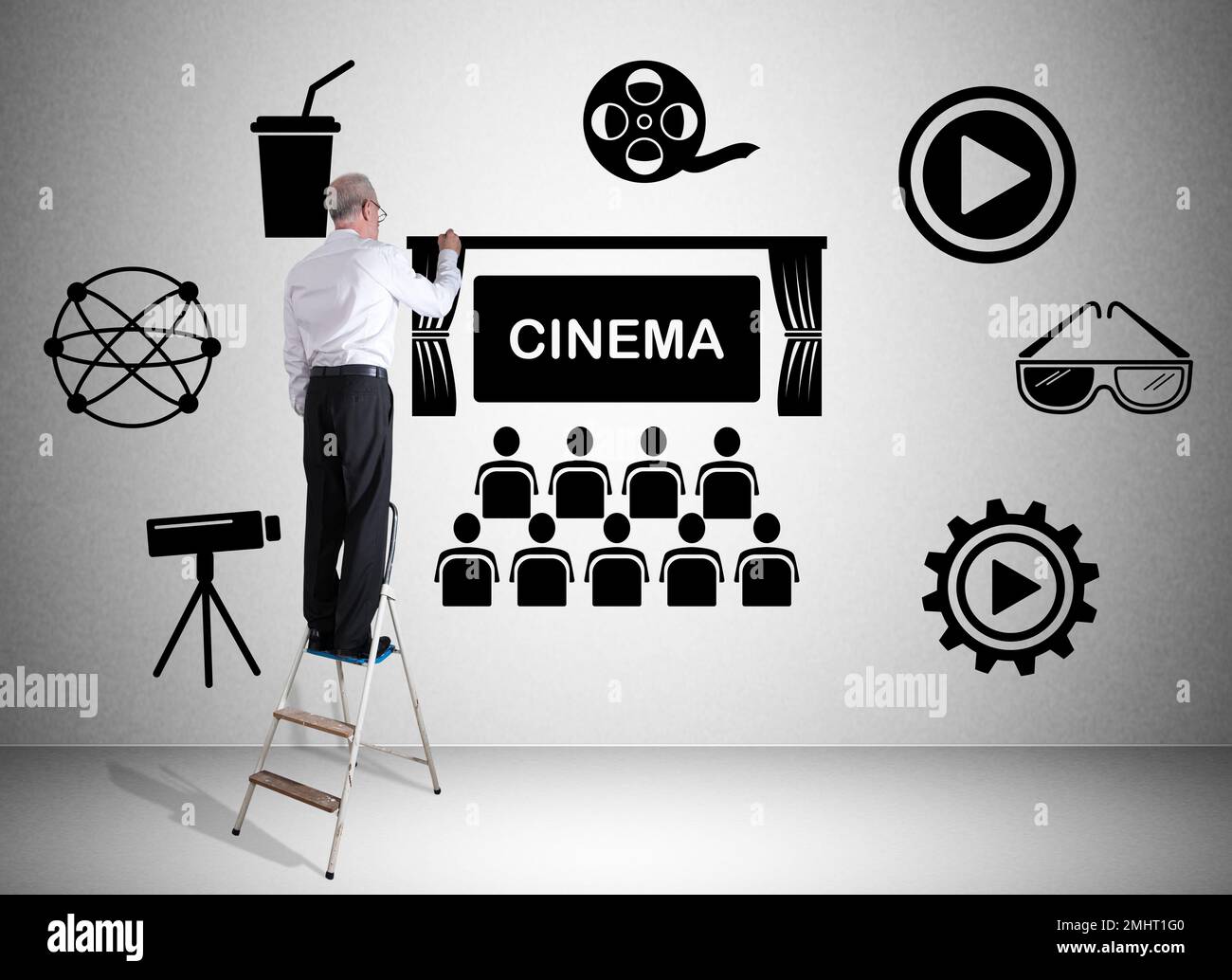 Man on a ladder drawing cinema concept on a wall Stock Photo - Alamy