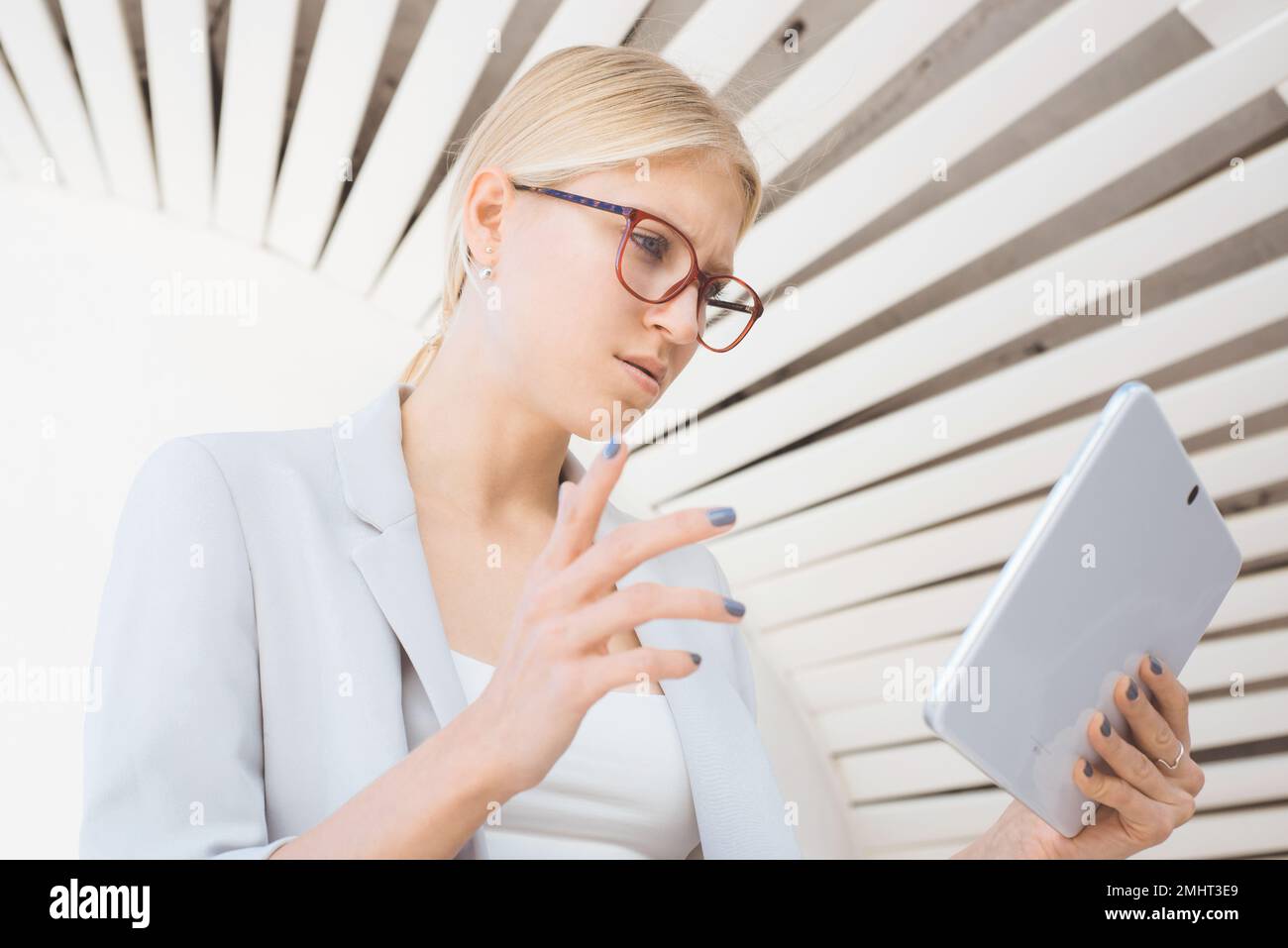Young woman looking at white tablet and something is broken, wrong or ...