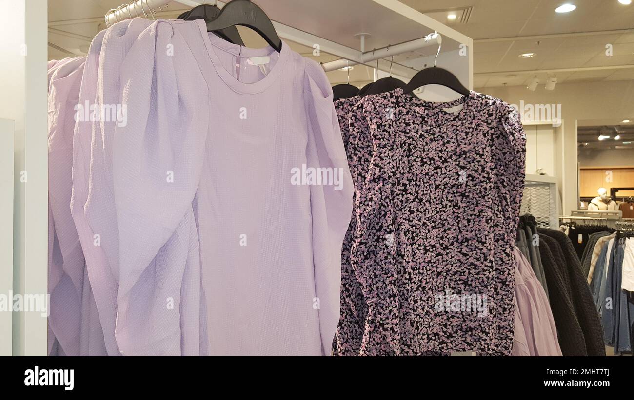 hanging women clothes on hangers in store Stock Photo - Alamy