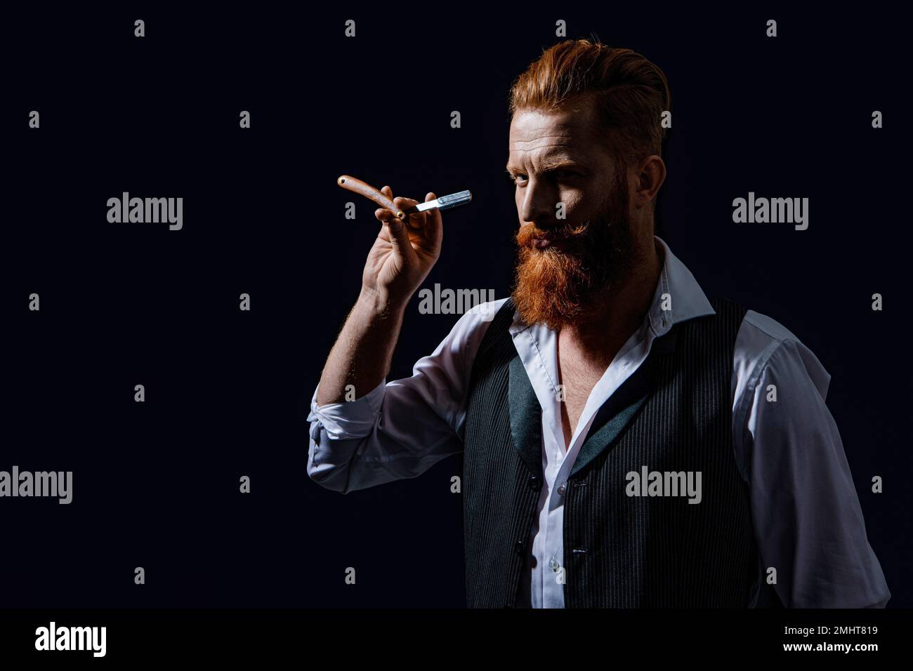 barbering man in studio with copy space. barbering man with retro razor ...