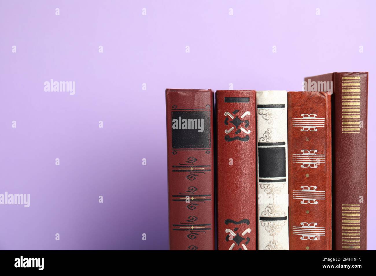 Collection of old books on violet background Stock Photo - Alamy
