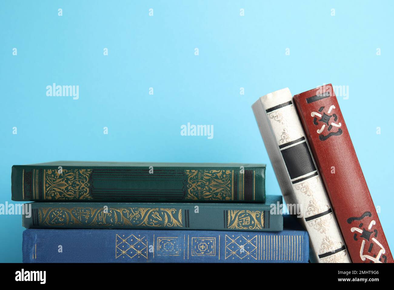 Collection of old books on light blue background Stock Photo - Alamy