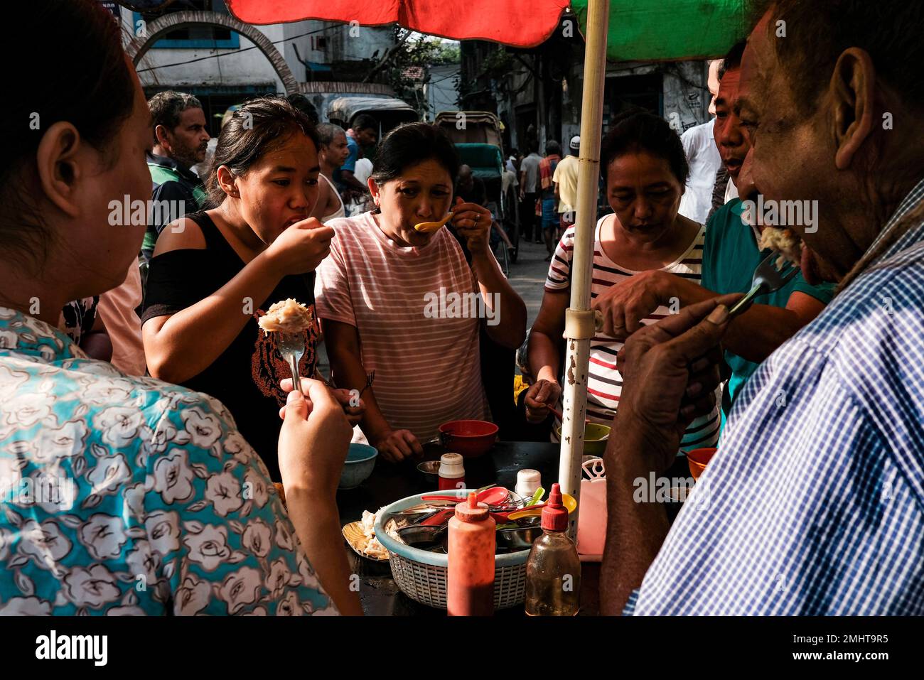 Chinese people of Indian origin have their breakfast at a market in ...