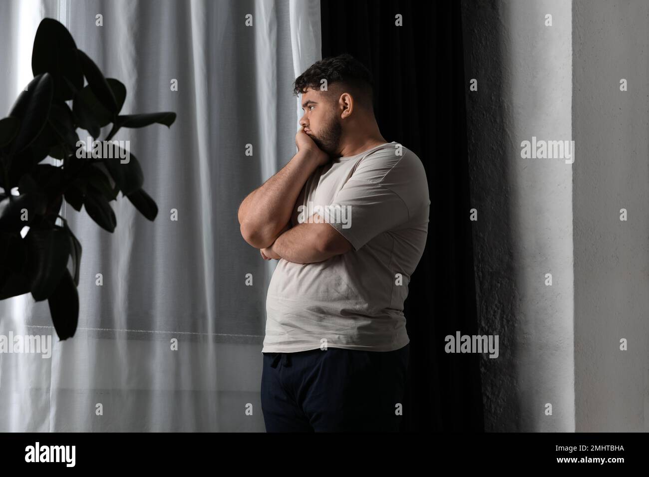 Overweight man suffering from depression at home Stock Photo - Alamy