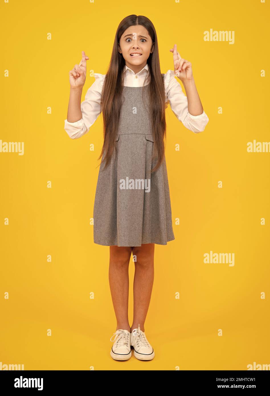 Portrait of adorable little teenager gitl standing with biting lips and ...