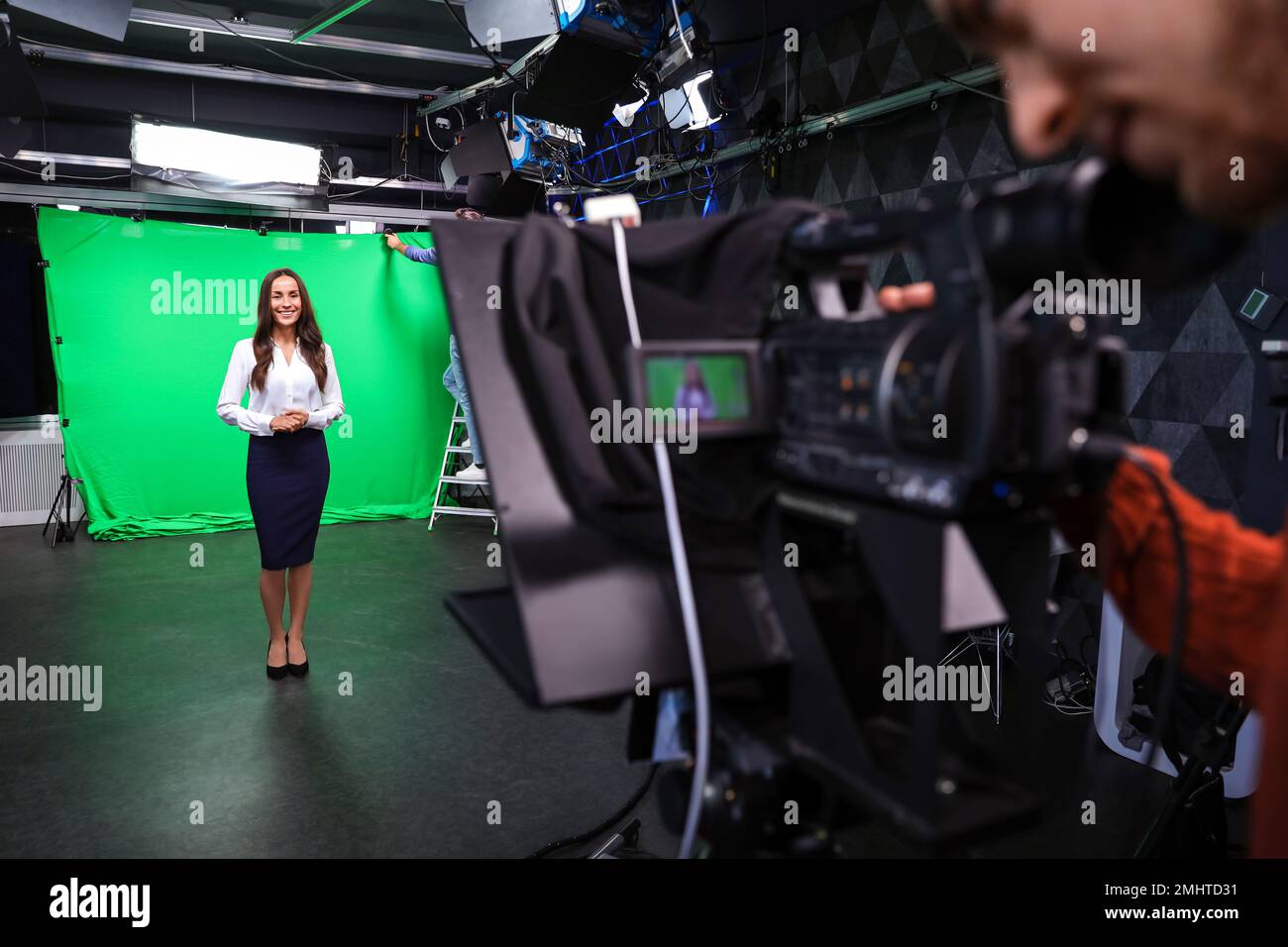 Presenter and video camera operator working in studio. News ...