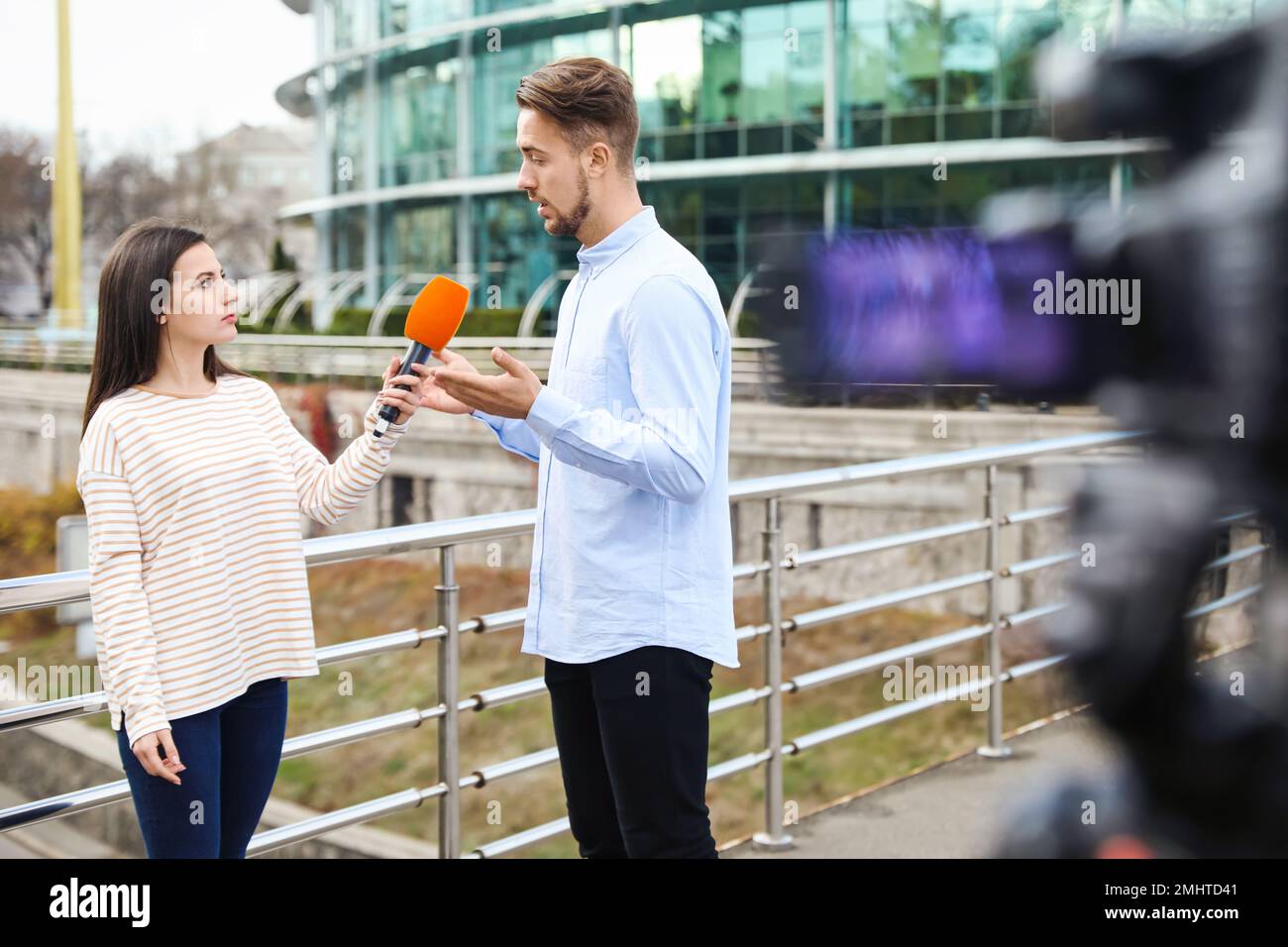 Young journalist interviewing man on city street Stock Photo - Alamy