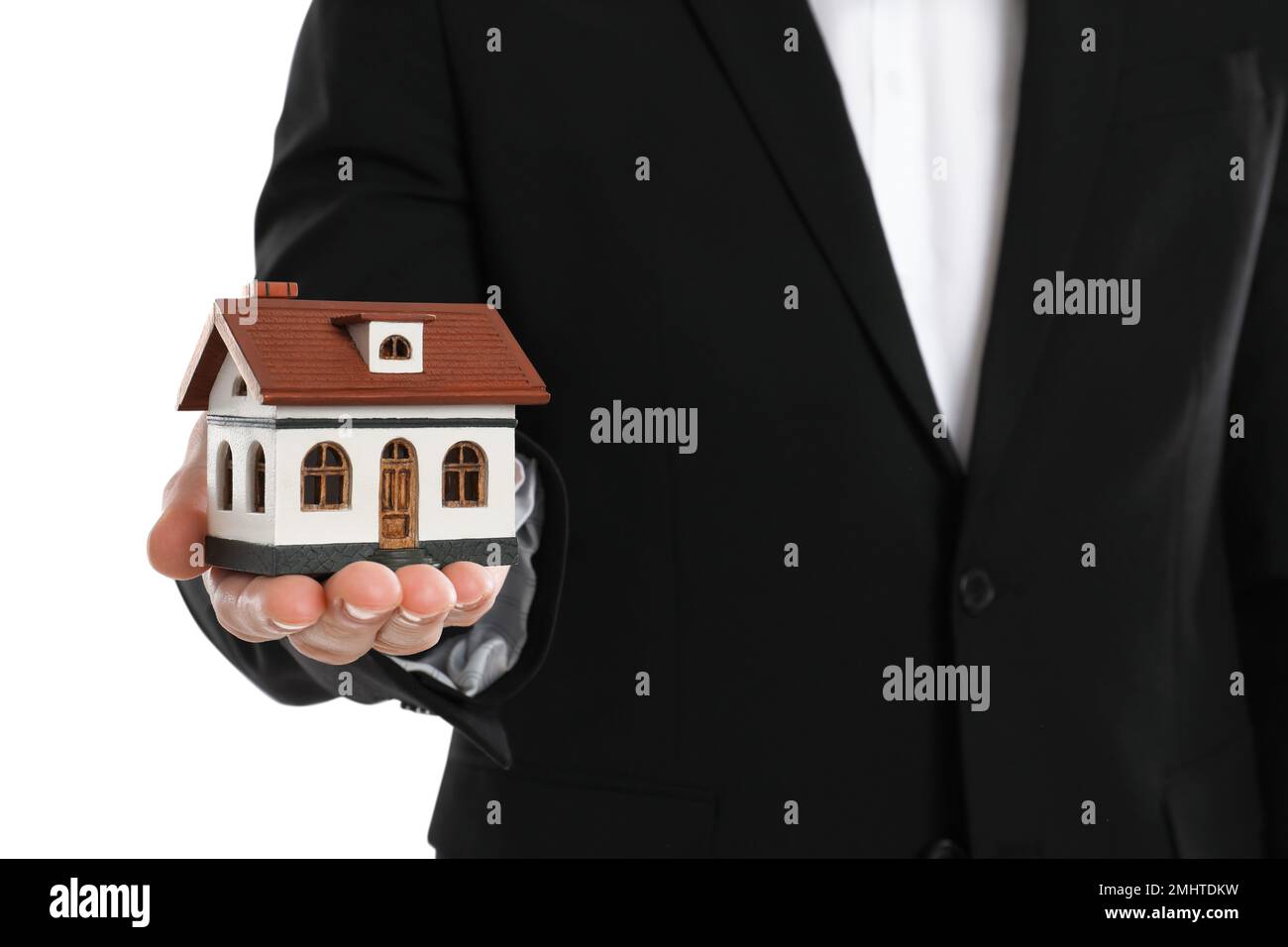 Real estate agent holding house model on white background, closeup ...