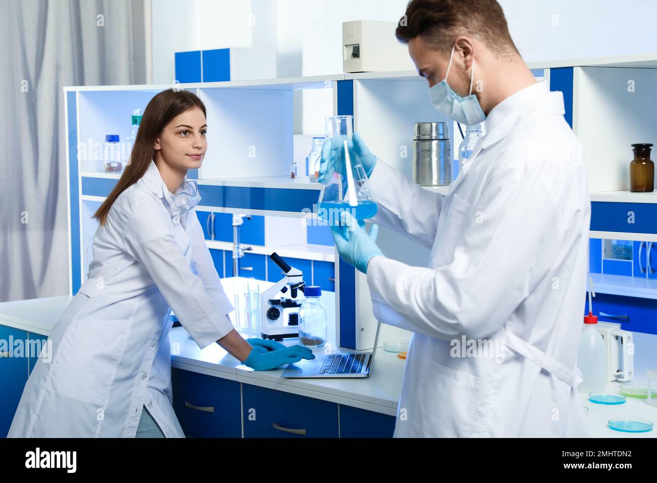 Young scientists doing research and analysis in chemical laboratory ...