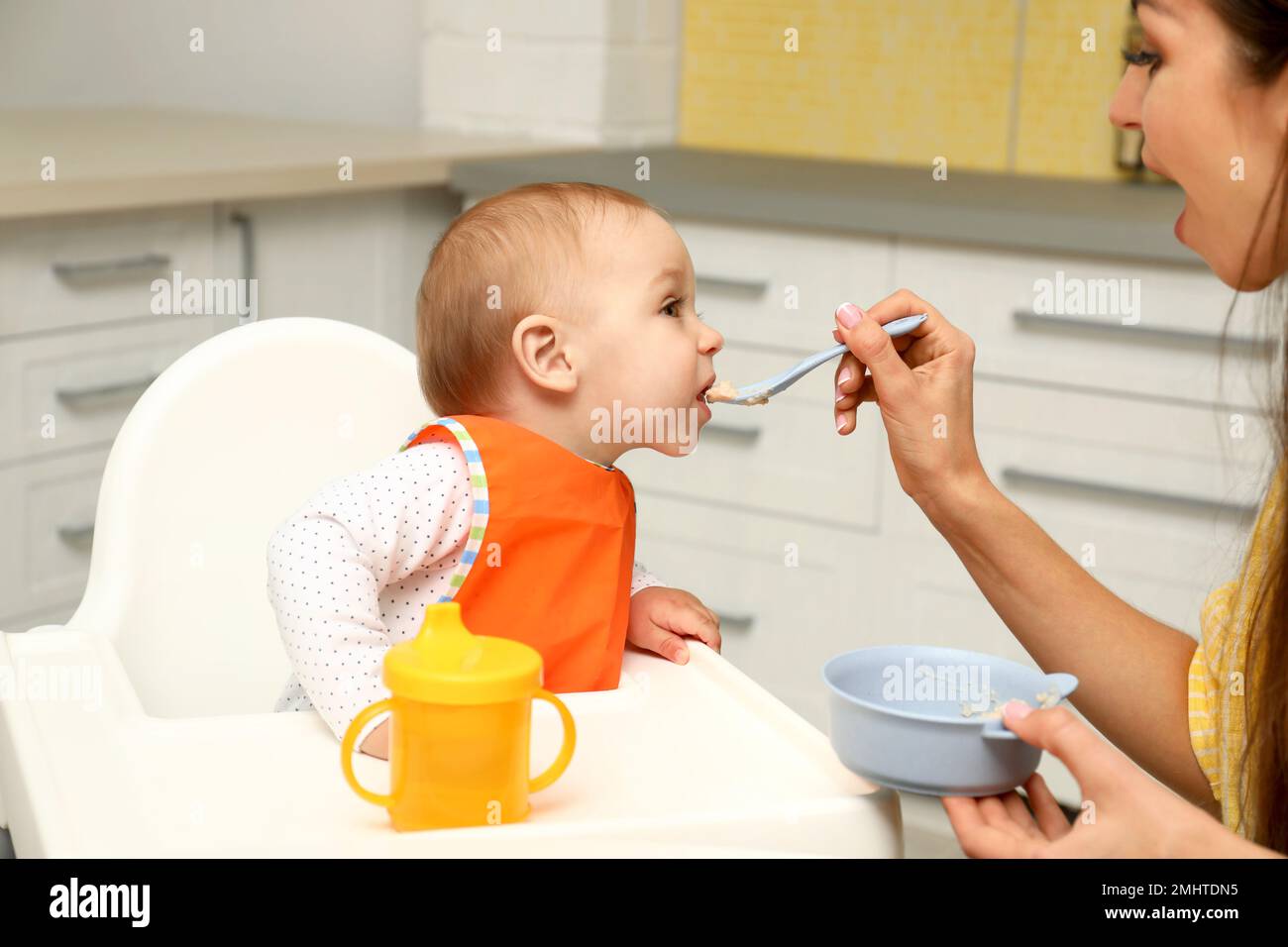 Young mother feeding her little baby at home Stock Photo - Alamy