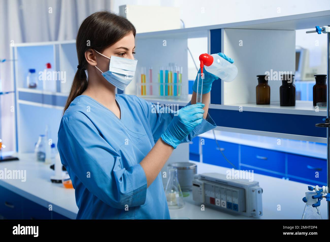 Scientist pouring liquid into test tube indoors. Laboratory analysis ...