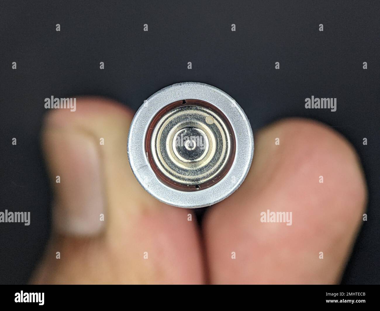 Closeup fingers holding a batteries on a black background Stock Photo ...