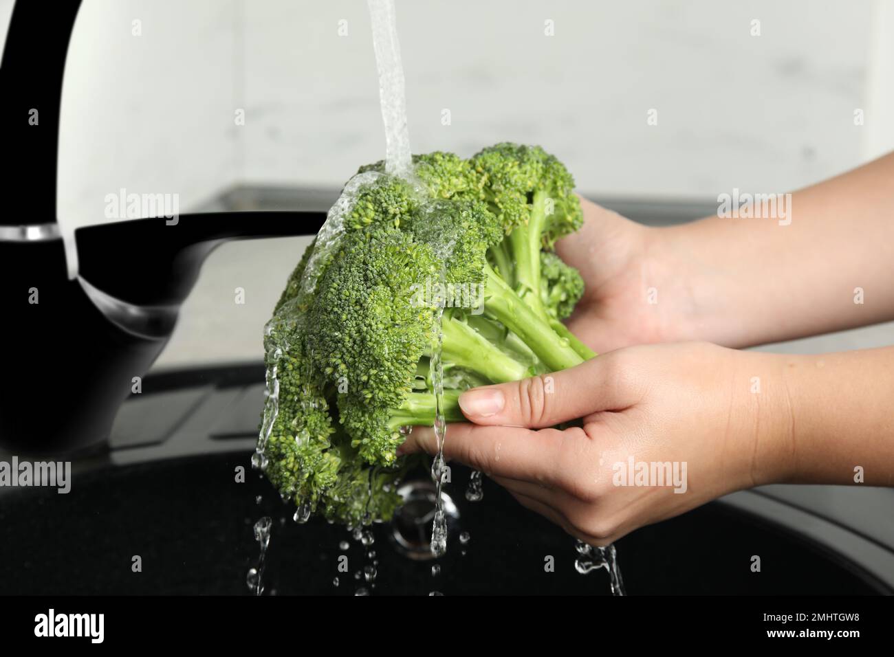 Woman washing fresh green broccoli in kitchen sink, closeup Stock Photo ...