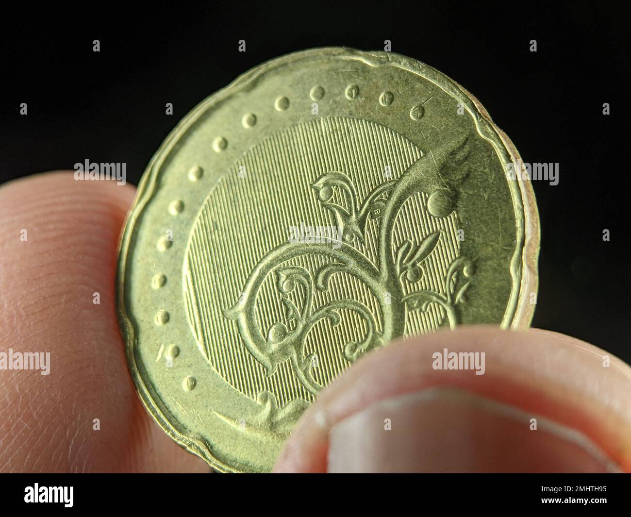Closeup finger holding 50 cent Malaysia coin on a black background ...