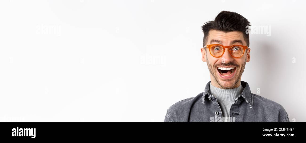 Excited funny man in glasses smiling, look with amazement and joy at ...