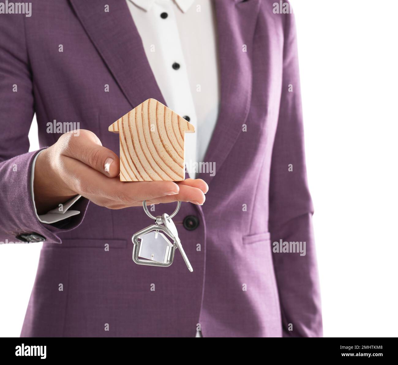 Real estate agent holding house figure and key on white background ...
