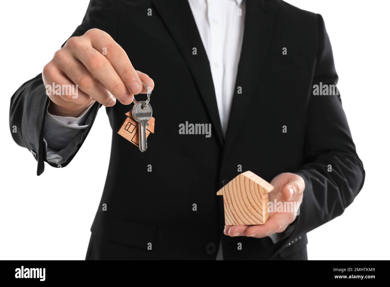 Real estate agent holding house figure and key on white background ...