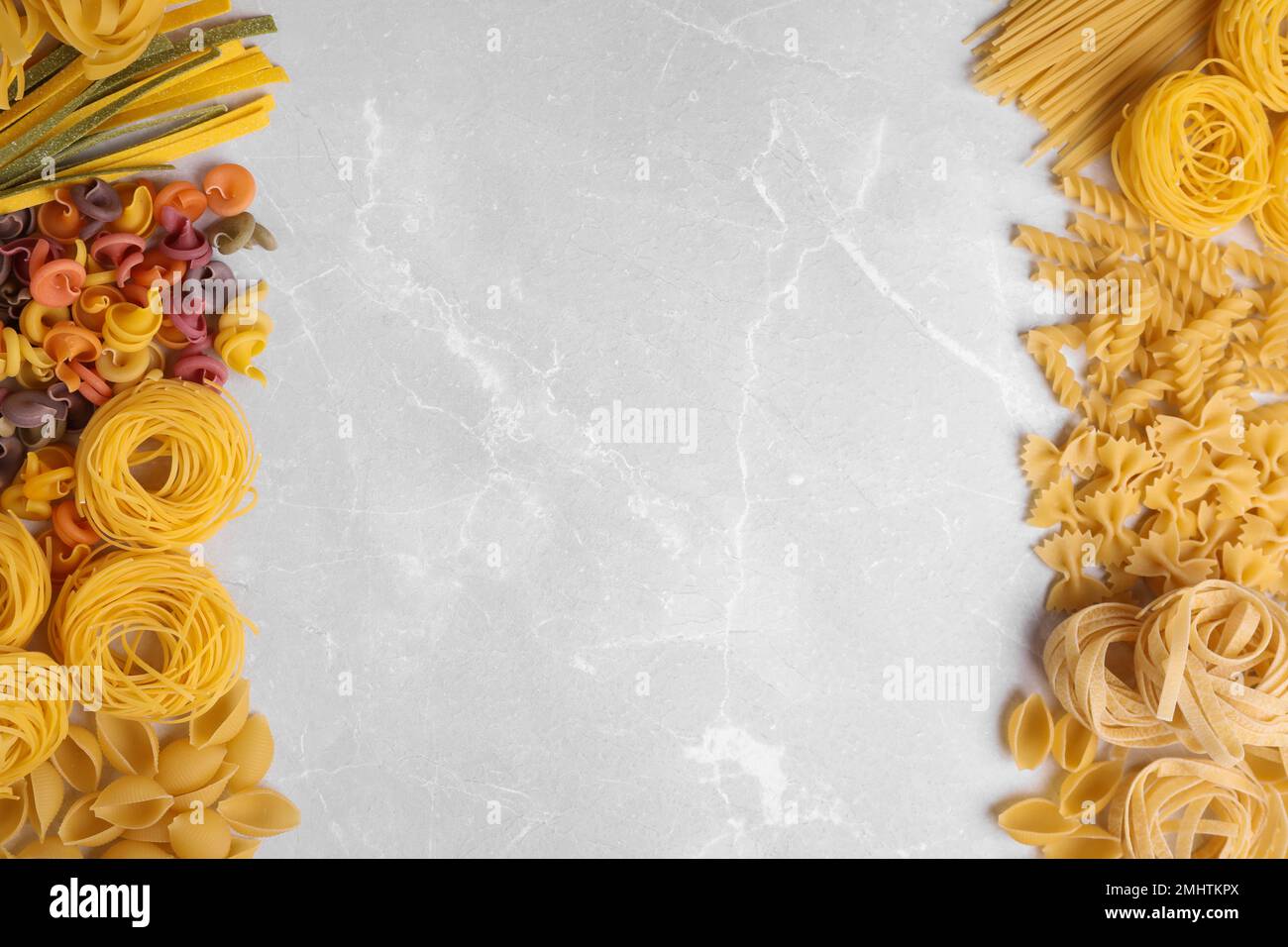 Different types of pasta on light grey marble table, flat lay. Space ...