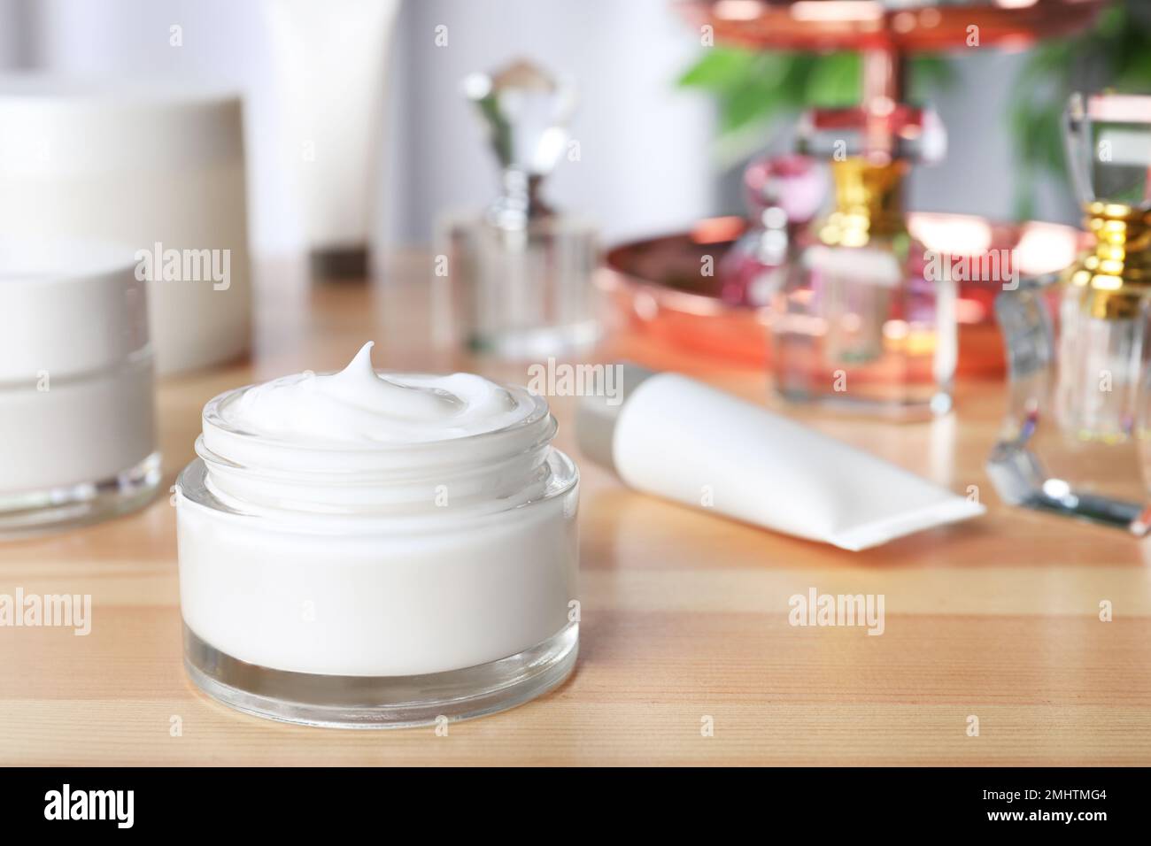 Open jar of cream on wooden dressing table. Space for text Stock Photo ...