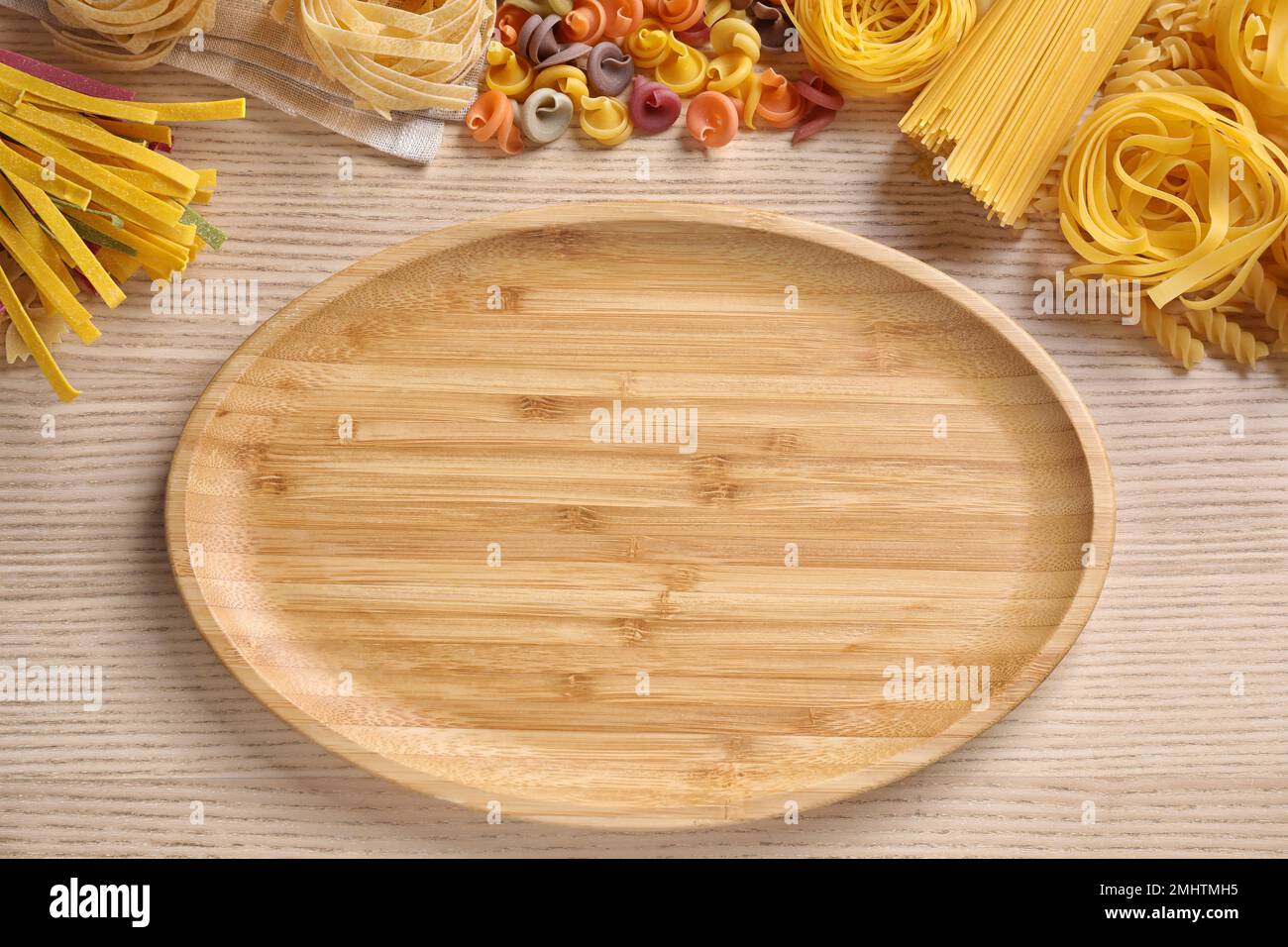 Flat lay composition with different types of pasta and empty plate on ...