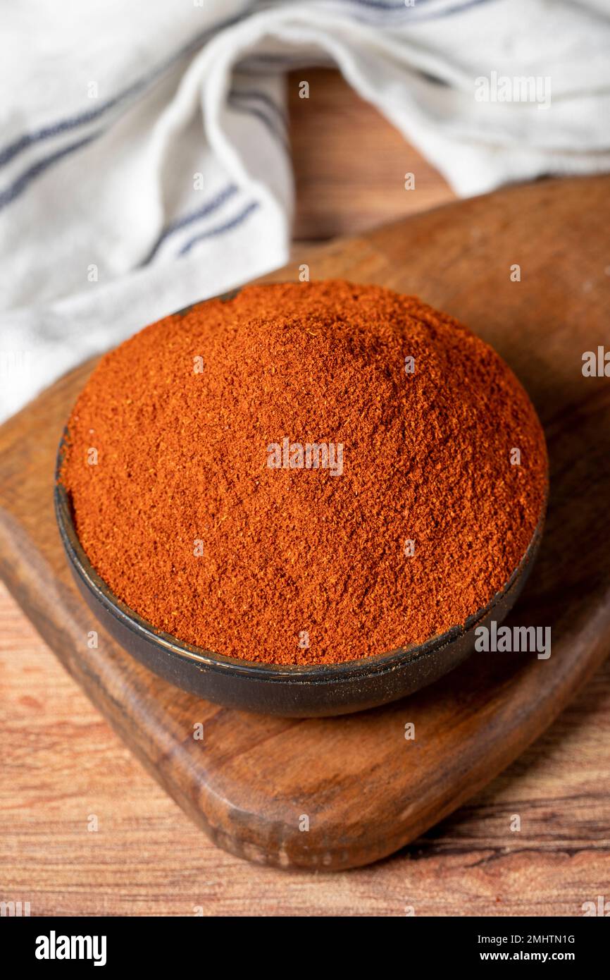 Red chili powder spice. Ground sweet paprika spice in bowl on wood ...