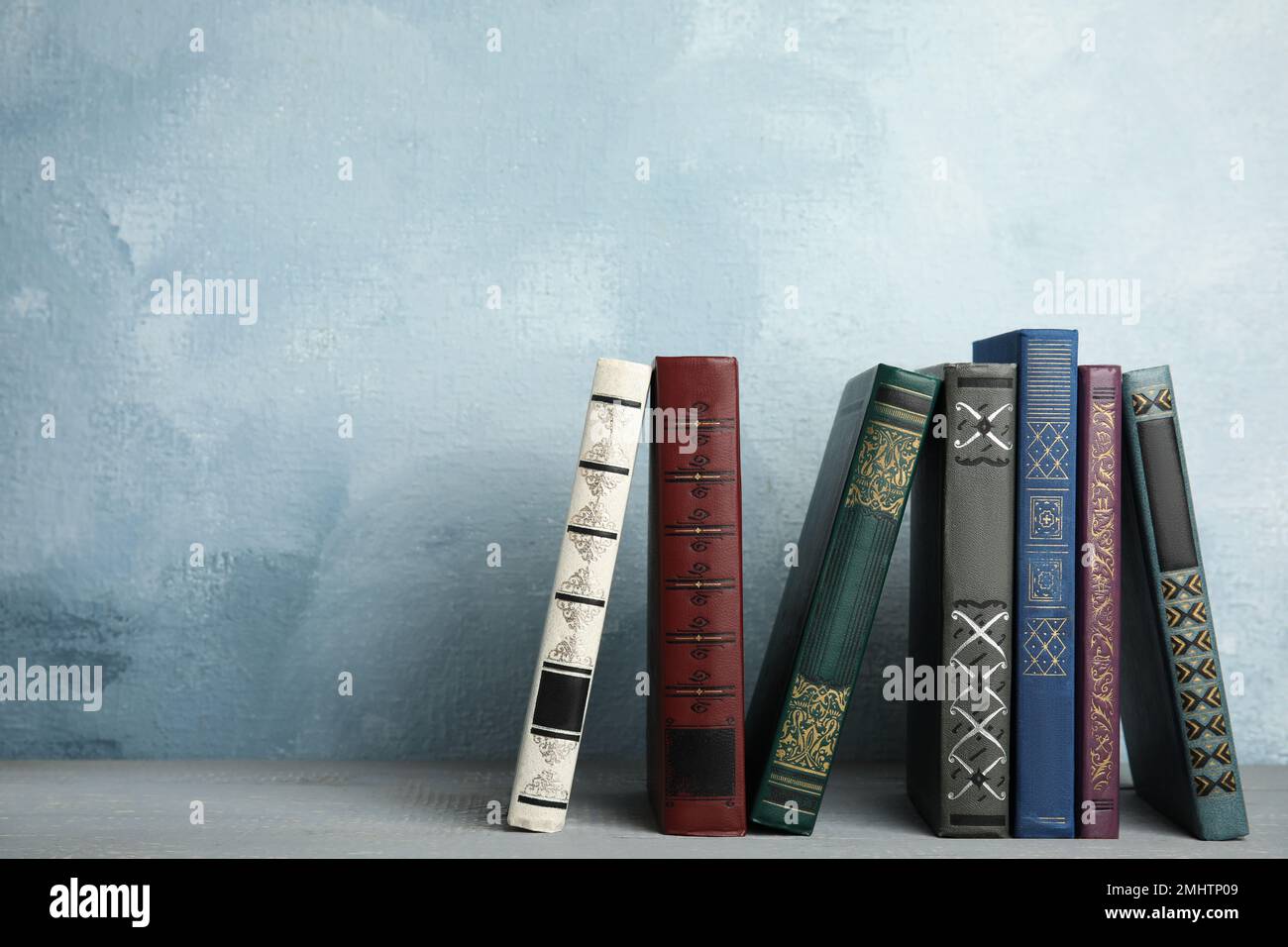 Collection of old books on grey wooden shelf. Space for text Stock ...