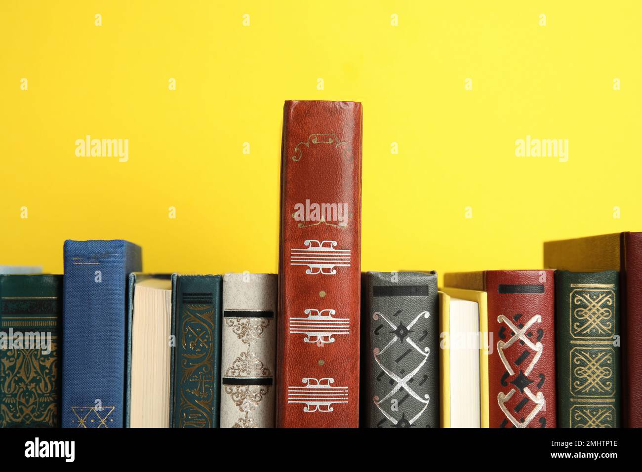 Collection of old books on yellow background Stock Photo - Alamy