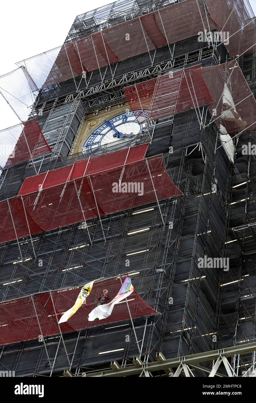 A climate protester demonstrates with banners on the scaffolding ...