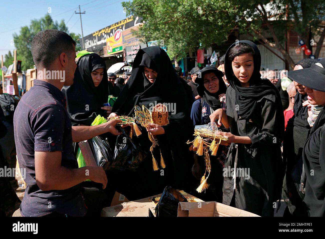 Iranian Shiite pilgrims shop outside the holy shrine of Imam Hussein ...