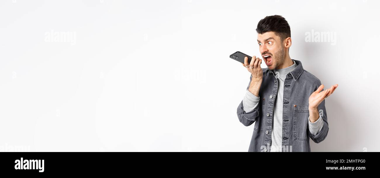 Angry guy shouting at speakerphone, scream on mobile phone, leaving ...