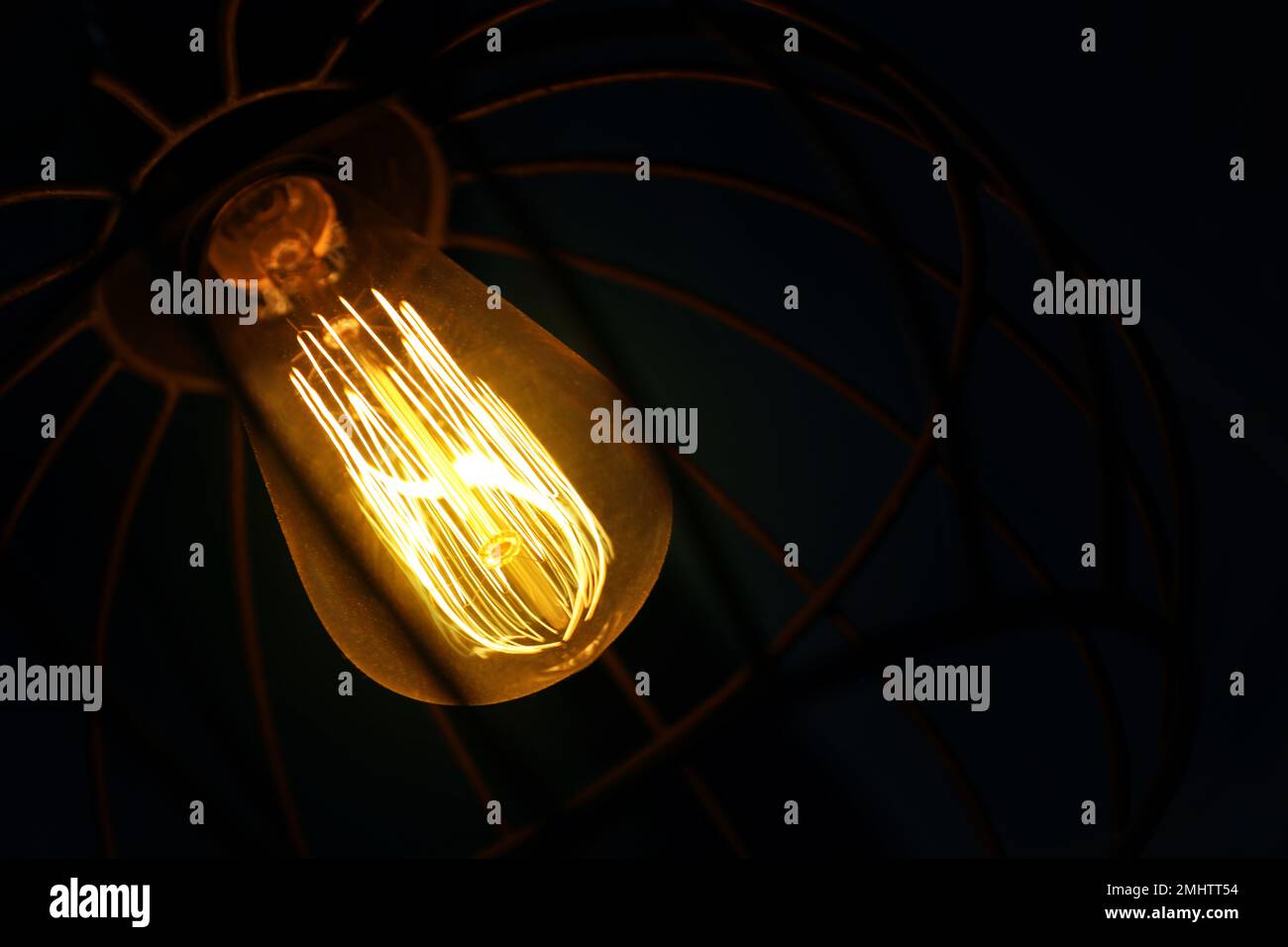 Stylish metallic pendant lamp with Edison light bulb indoors, closeup ...