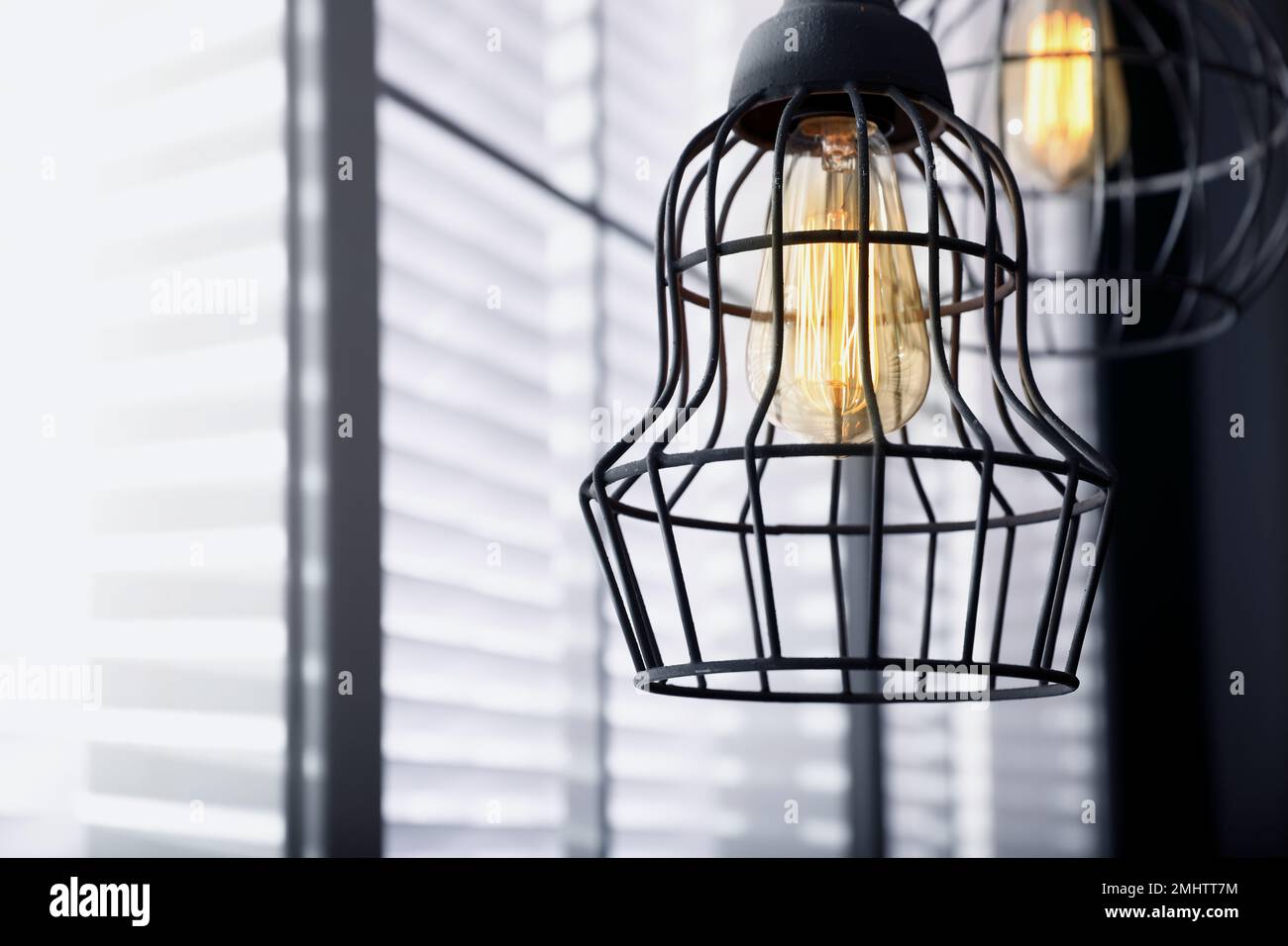 Stylish metallic pendant lamp with Edison light bulb indoors Stock ...