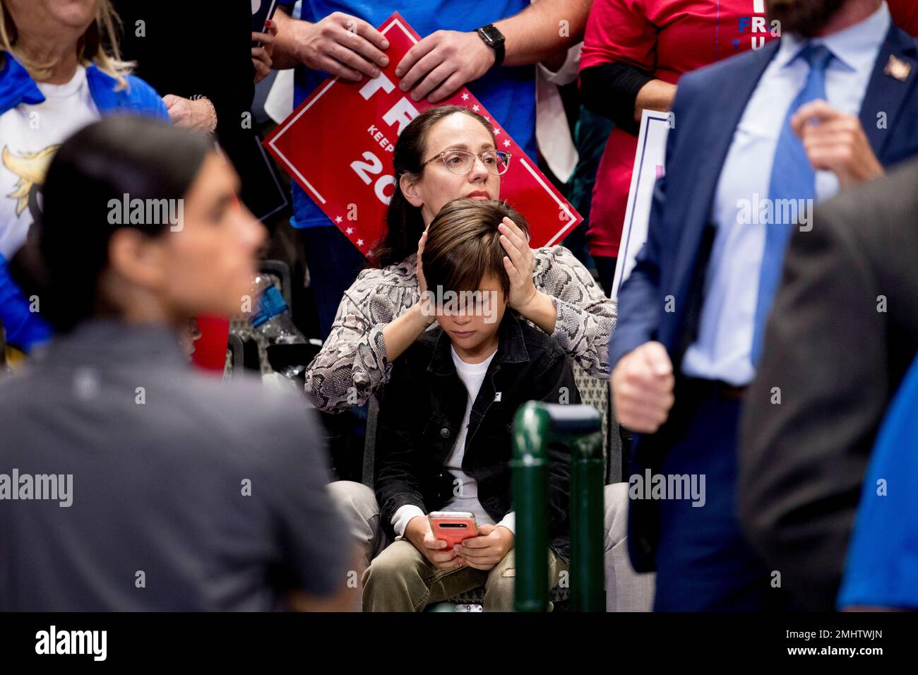 A member of the audience covers the ears of a boy as the music in the ...